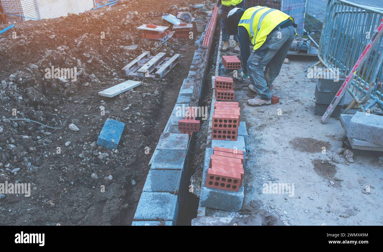 Hard working bricklayer laying concrete blocks on top of concrete ...