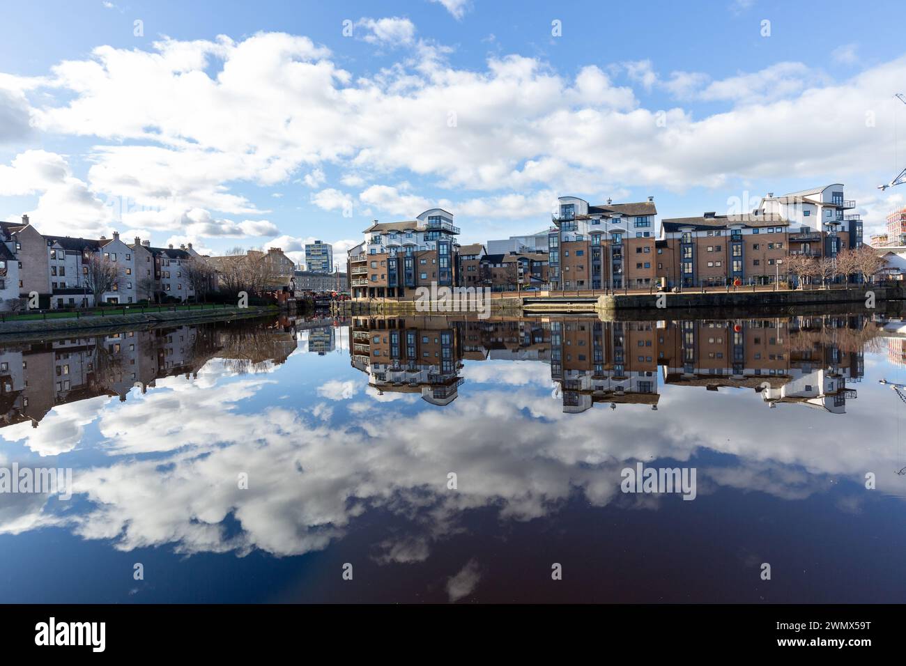 A mirror like reflection of clouds on the Water of Leith, Edinburgh ...