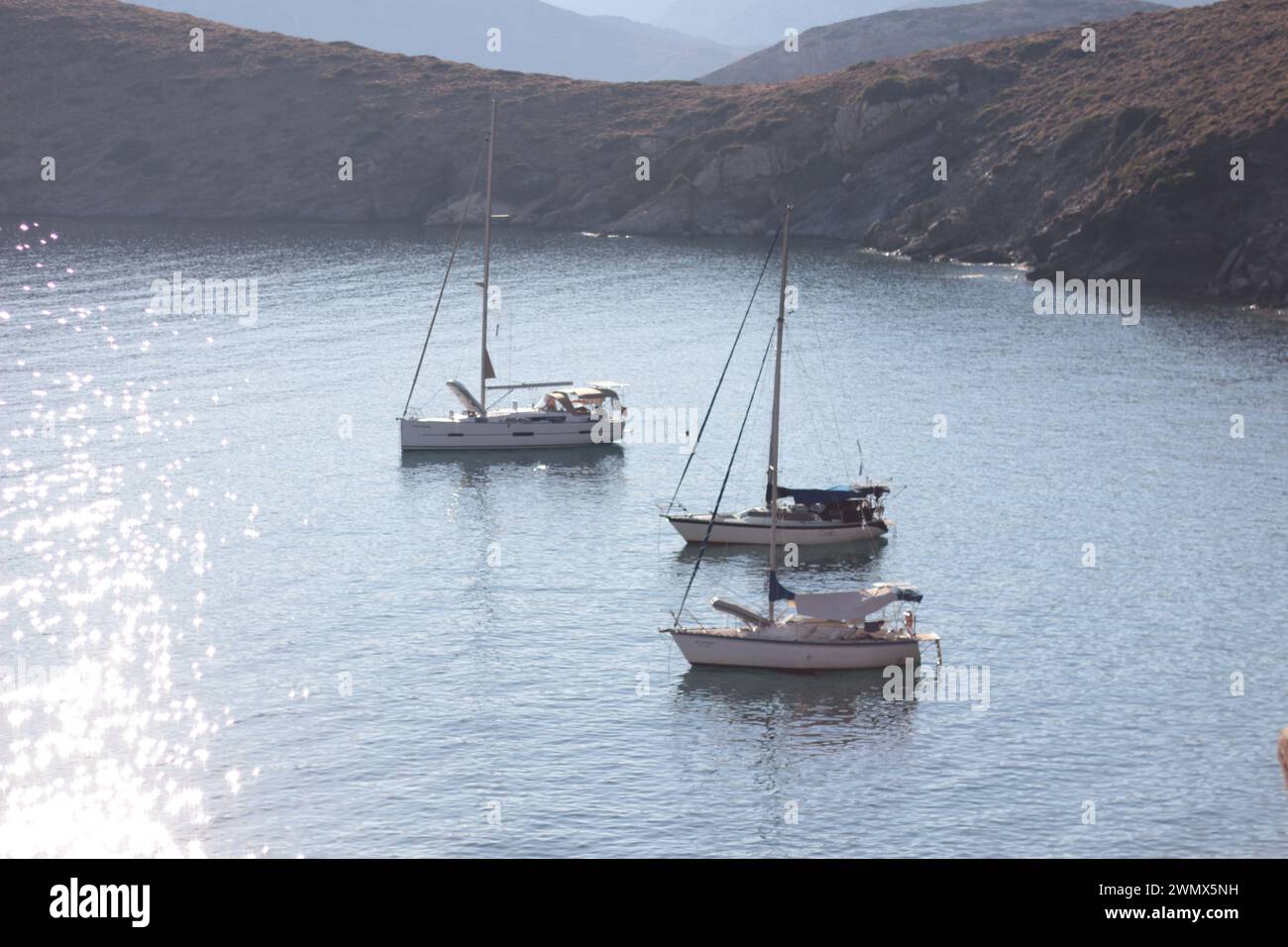 In the tranquil embrace of a secluded bay on Fourni Island, three boats ...