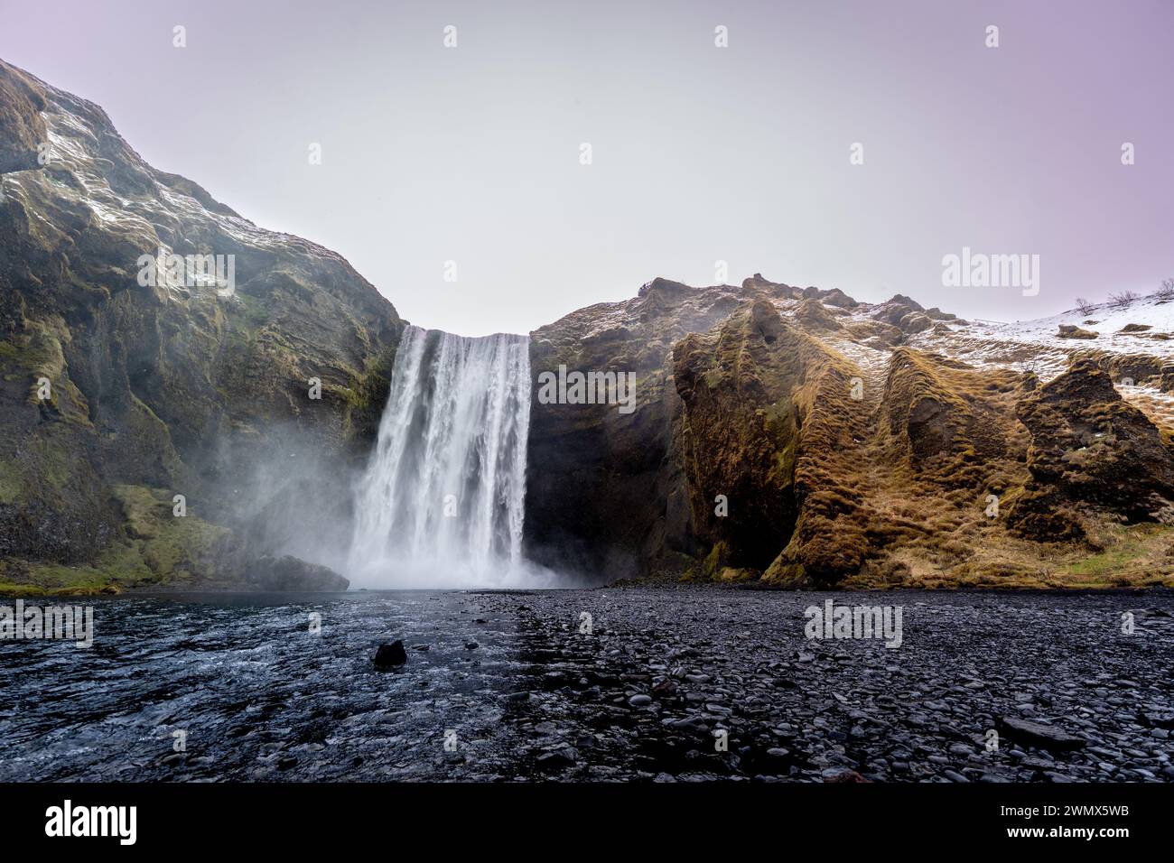 A scenic waterfall cascading with a towering cliff backdrop. Iceland ...