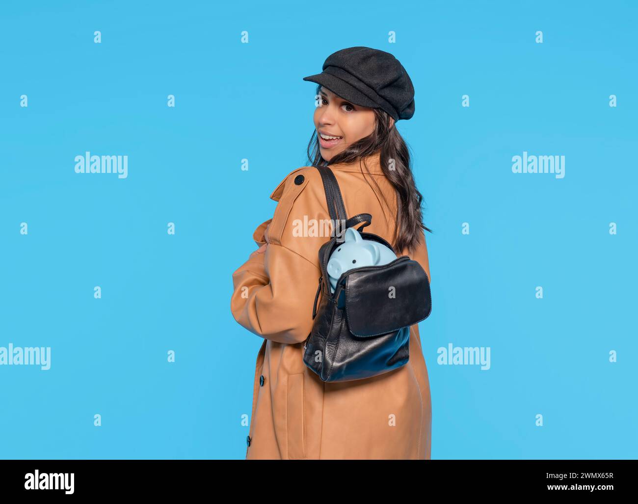 happy Indian woman in a brown coat saving money for a rainy day in the ...