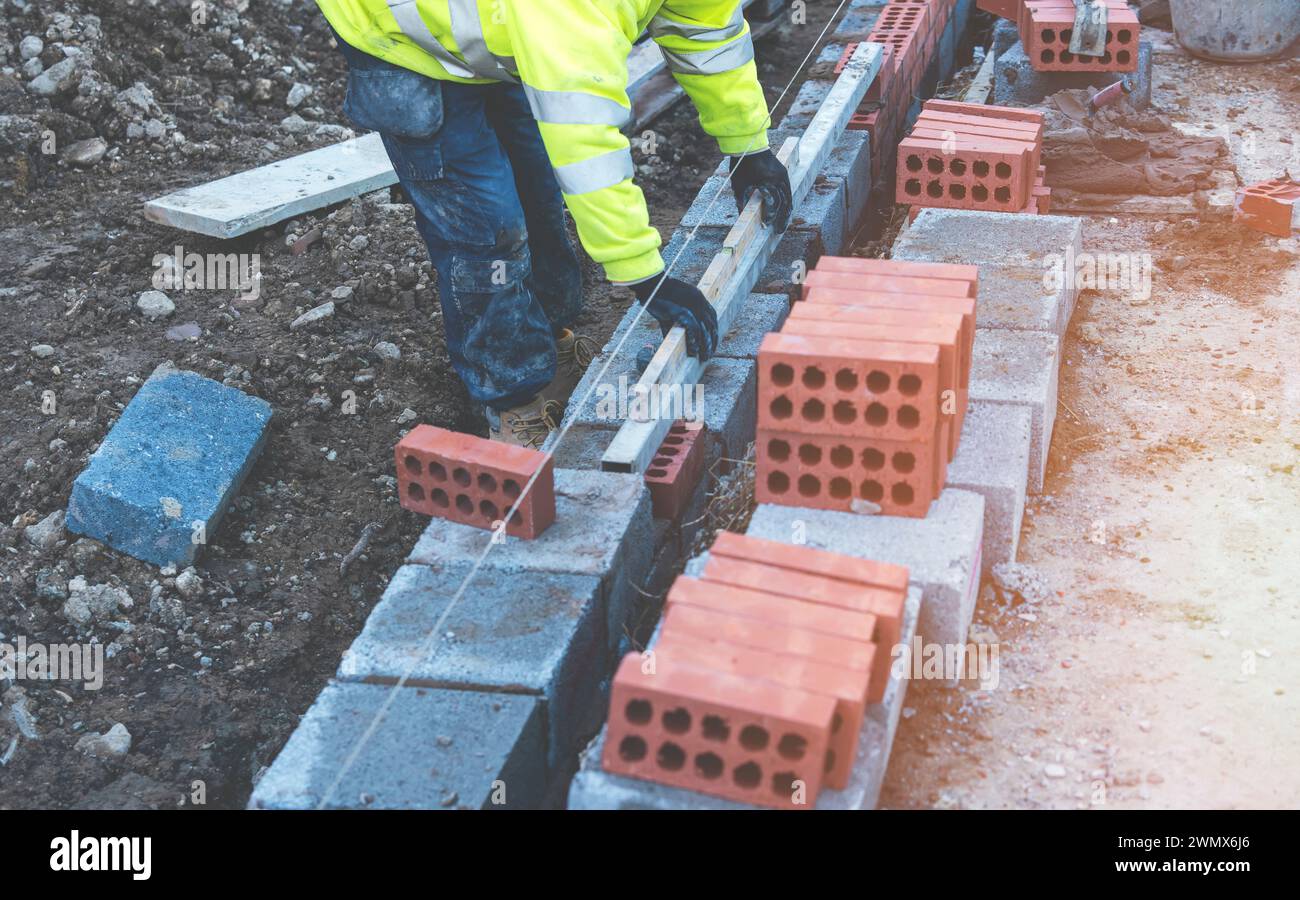 Hard working bricklayer laying concrete blocks on top of concrete ...