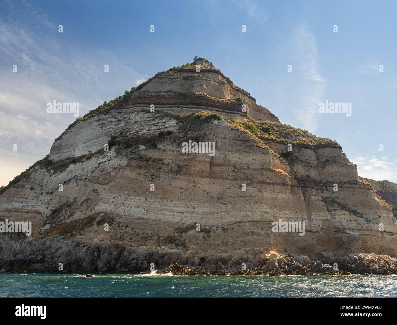 Weathered seaside rock face texture with parts of green and blue water ...