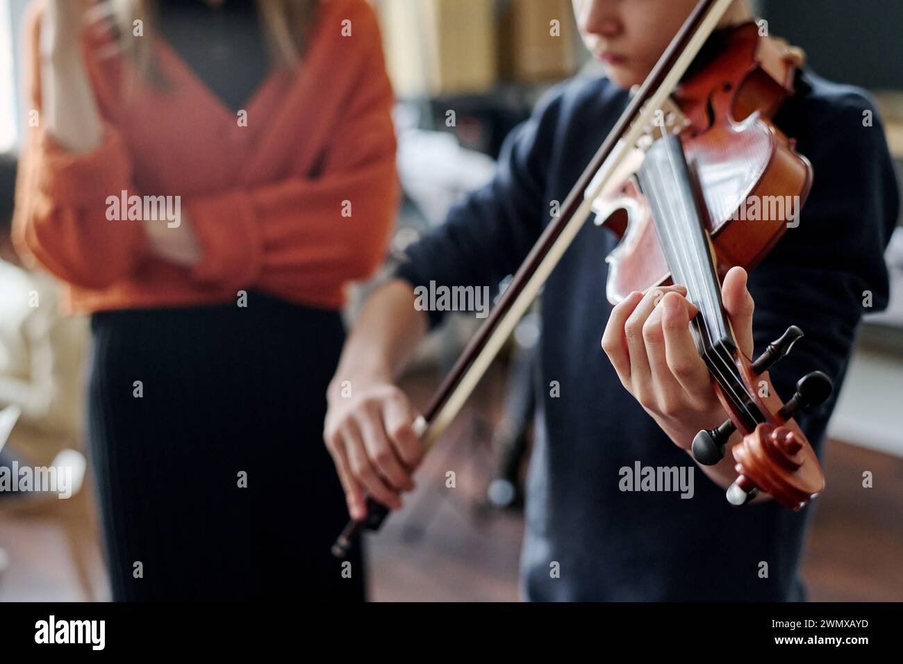 Selective focus shot of Caucasian teen boy learning to play violin at ...