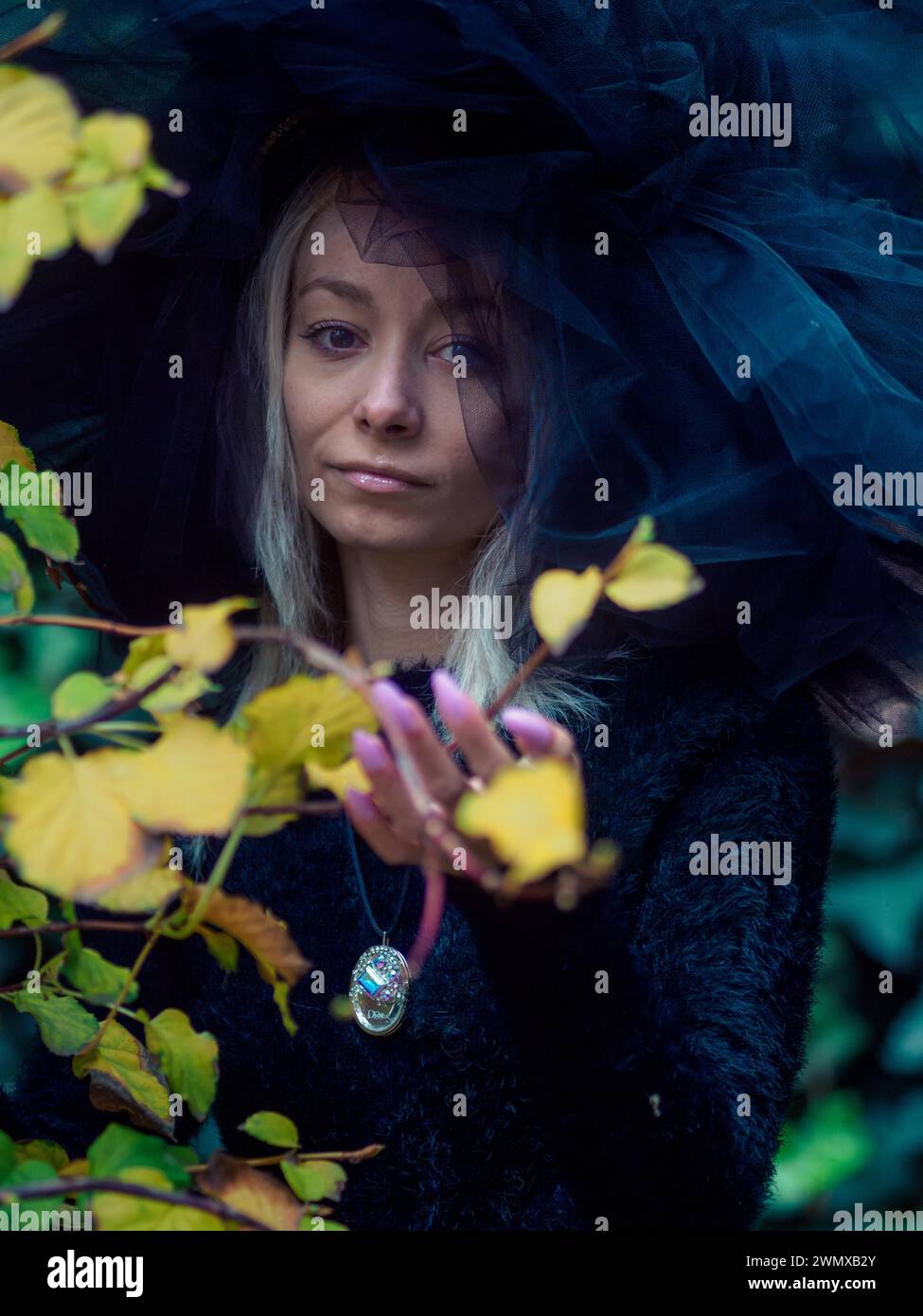 Colorful enchanting portrait of a woman with leaves around her, wearing ...