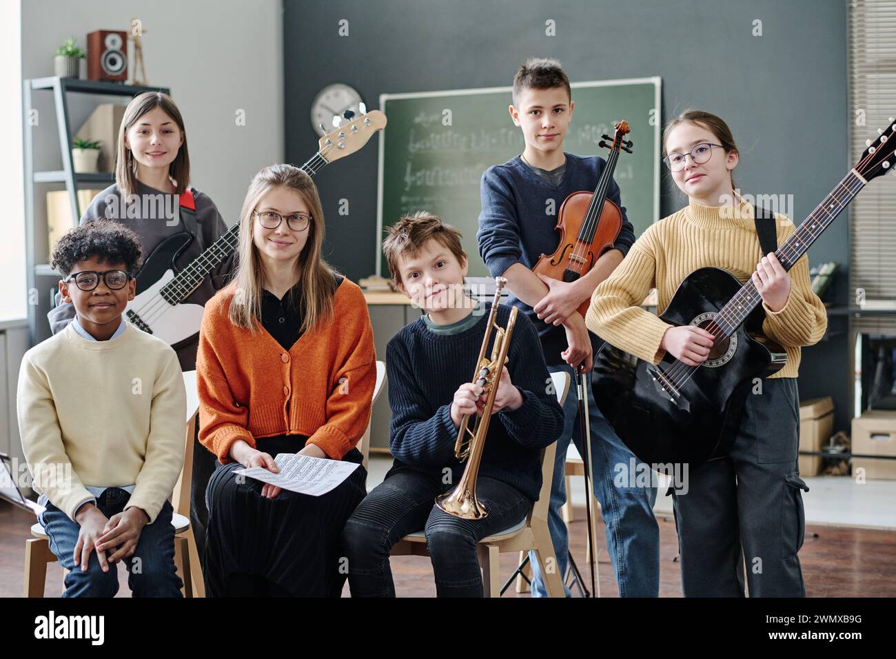 Group of boys and girls taking part in school orchestra and their young ...