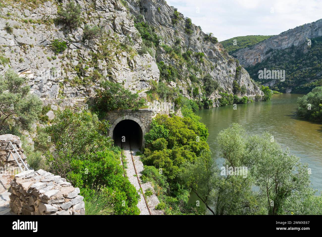Permeable railway tunnel next to a river, surrounded by a rocky landscape, River Nestos or Mesta ...