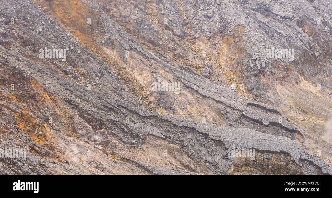 Layers of ash flows and erosion on the rocky slopes of a desolate ...
