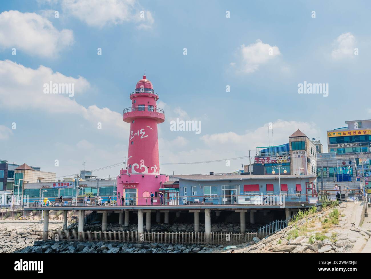 Oido red lighthouse on pier beside main street lined with businesses in ...