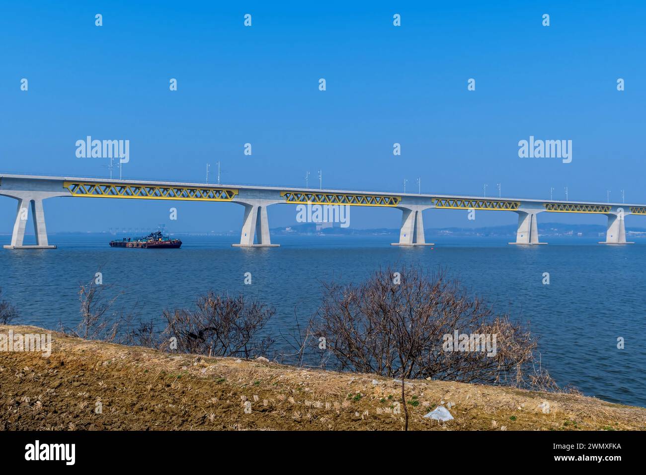 Flat bottom construction barge under bridge in lake on hazy morning in ...