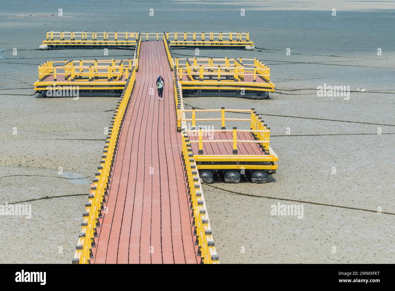Lone tourist walking on floating dock in Oido port during low tide in ...