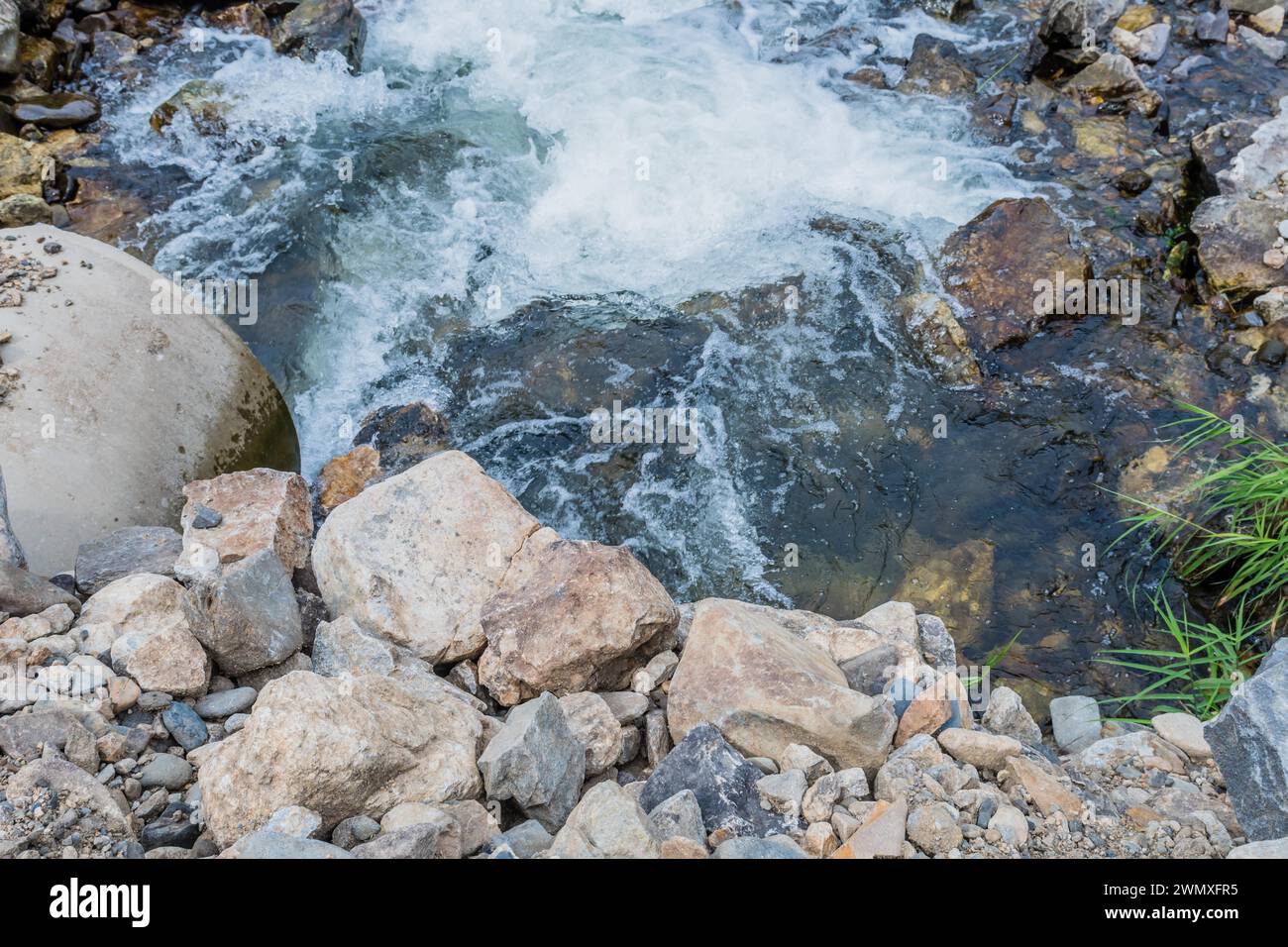 Top down view of water pouring through culvert from mountain river, in ...