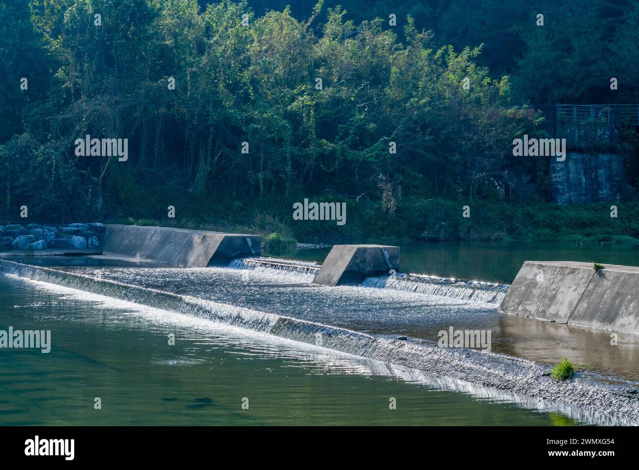 Water flowing over concrete aerator in small rural river, in South ...