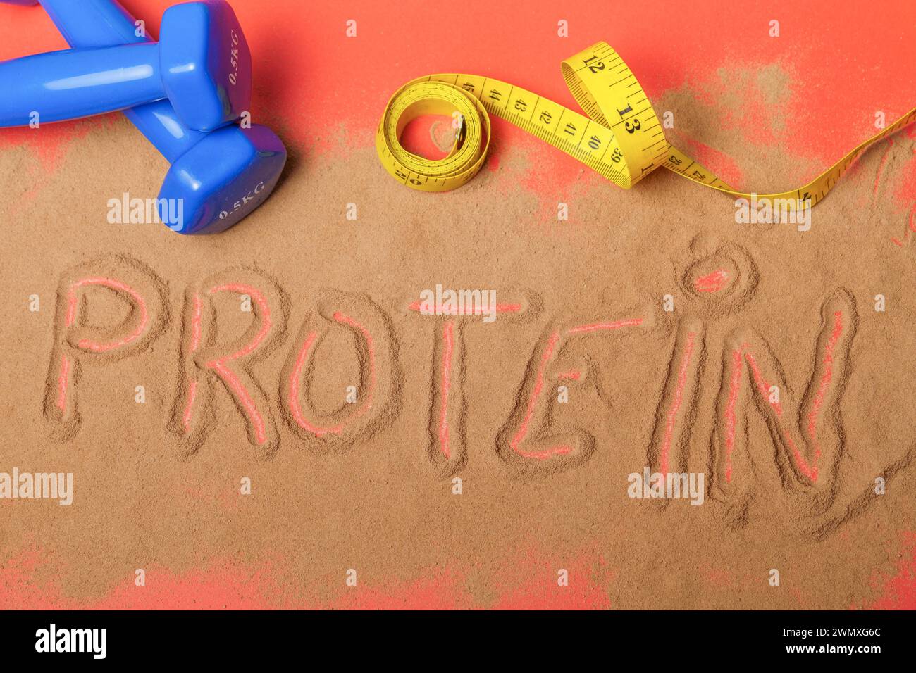 Word protein written on protein powder on red background, with ...