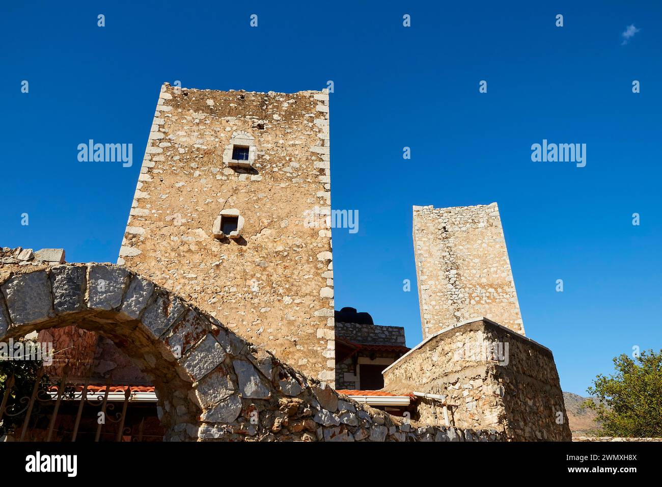 Stone towers of an ancient structure with an arch and blue sky in the ...