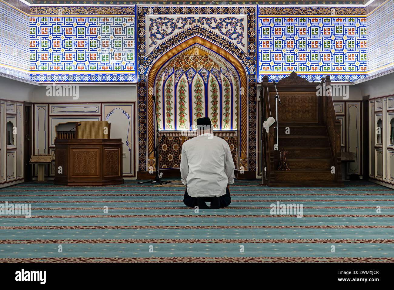 Back view of a Muslim man's while he prays in a mosque. Prayer inside a ...