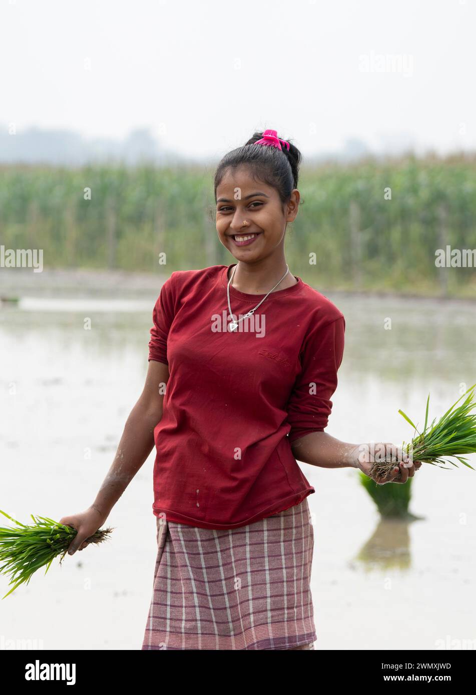 Morigaon, India. 20 February 2024. A women pose for photograph holding ...