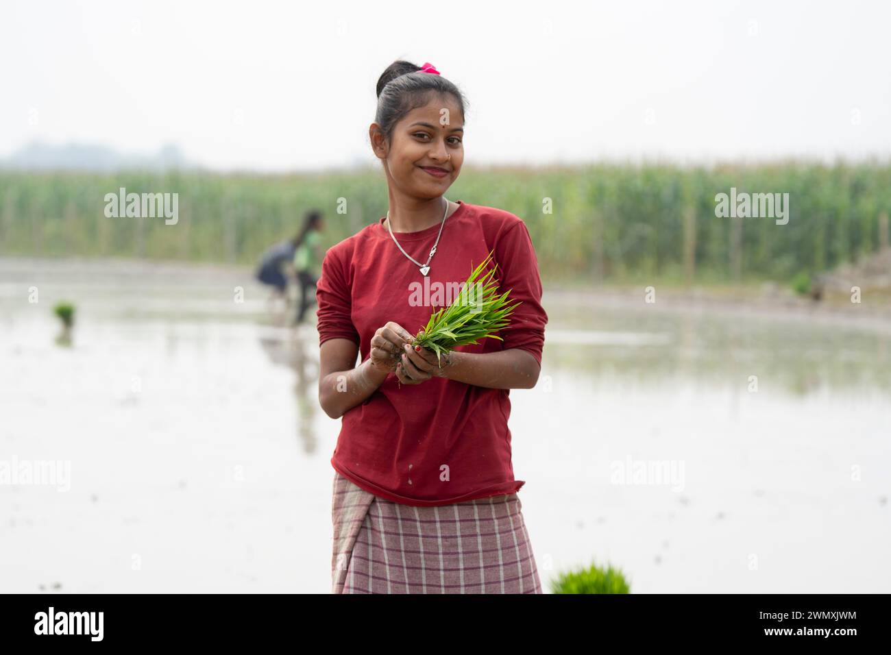 Morigaon, India. 20 February 2024. A women pose for photograph holding ...