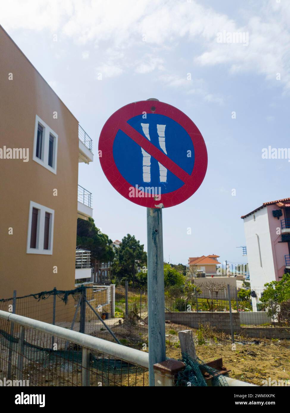 Red traffic sign with blue and white no parking symbol in front of ...