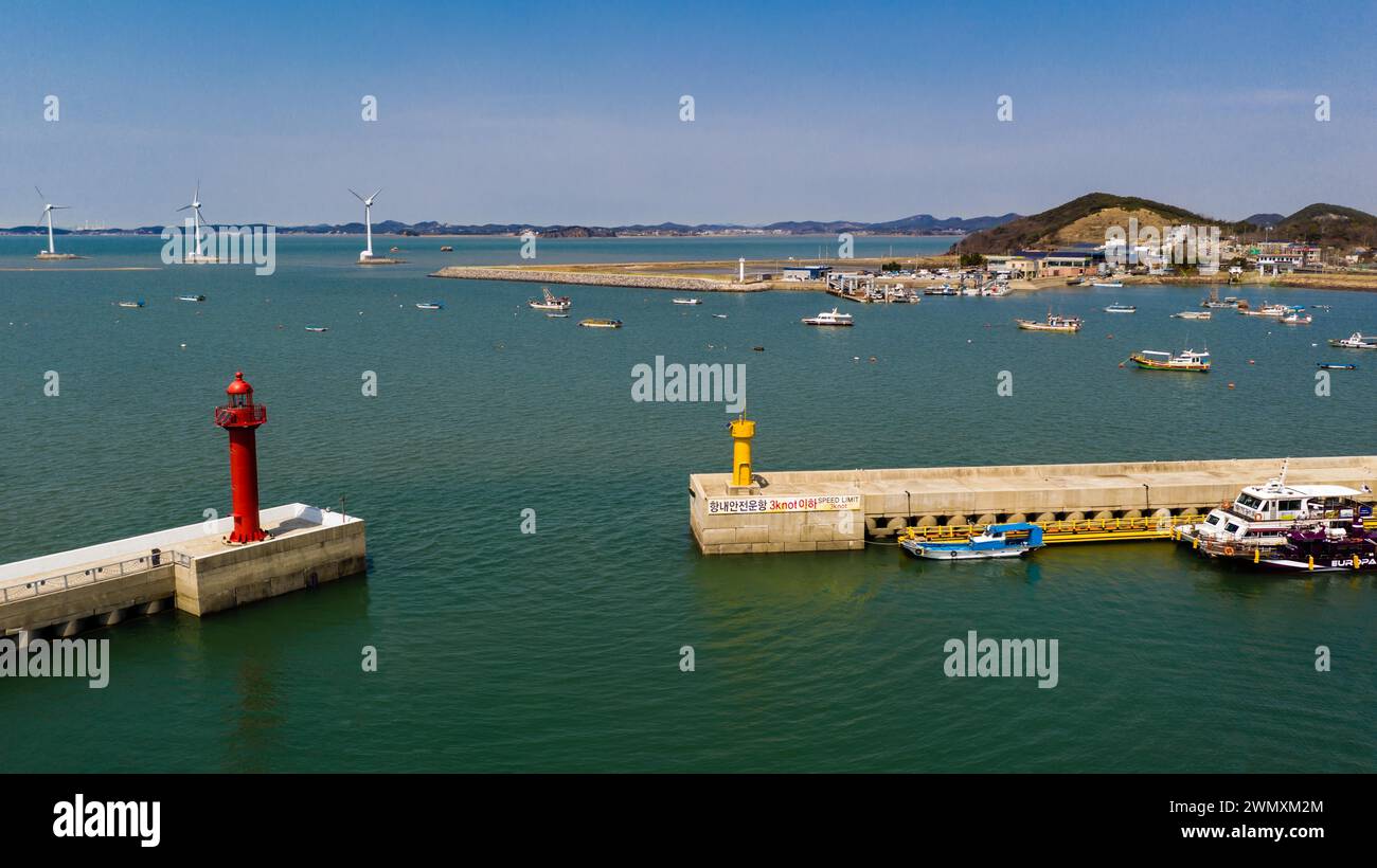 Aerial view of small port and pier with red and yellow lighthouses in ...