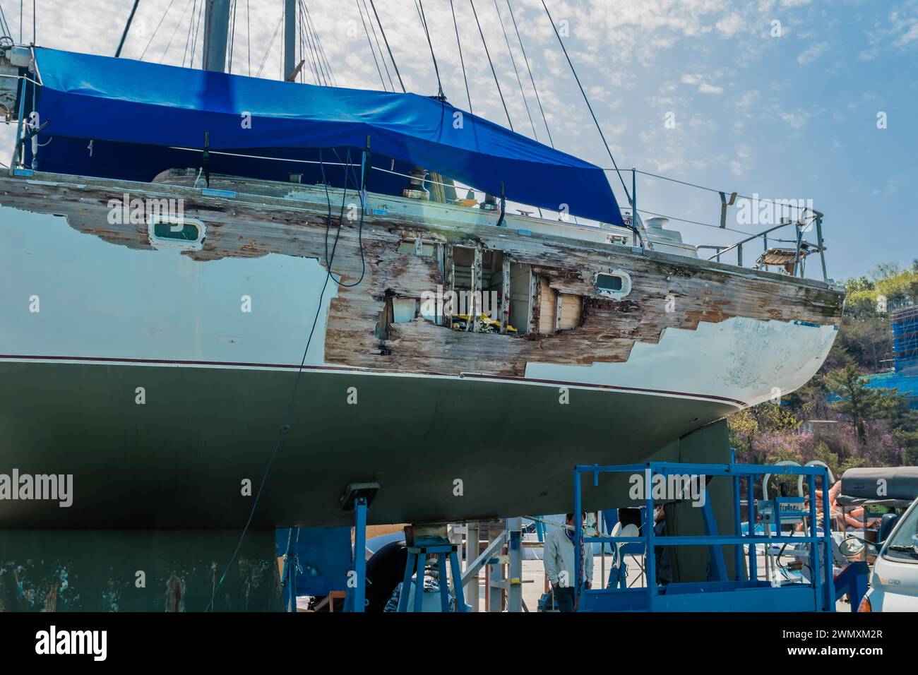 Sailboat in dry dock for repair with hole in side hull in Pyeongtaek ...