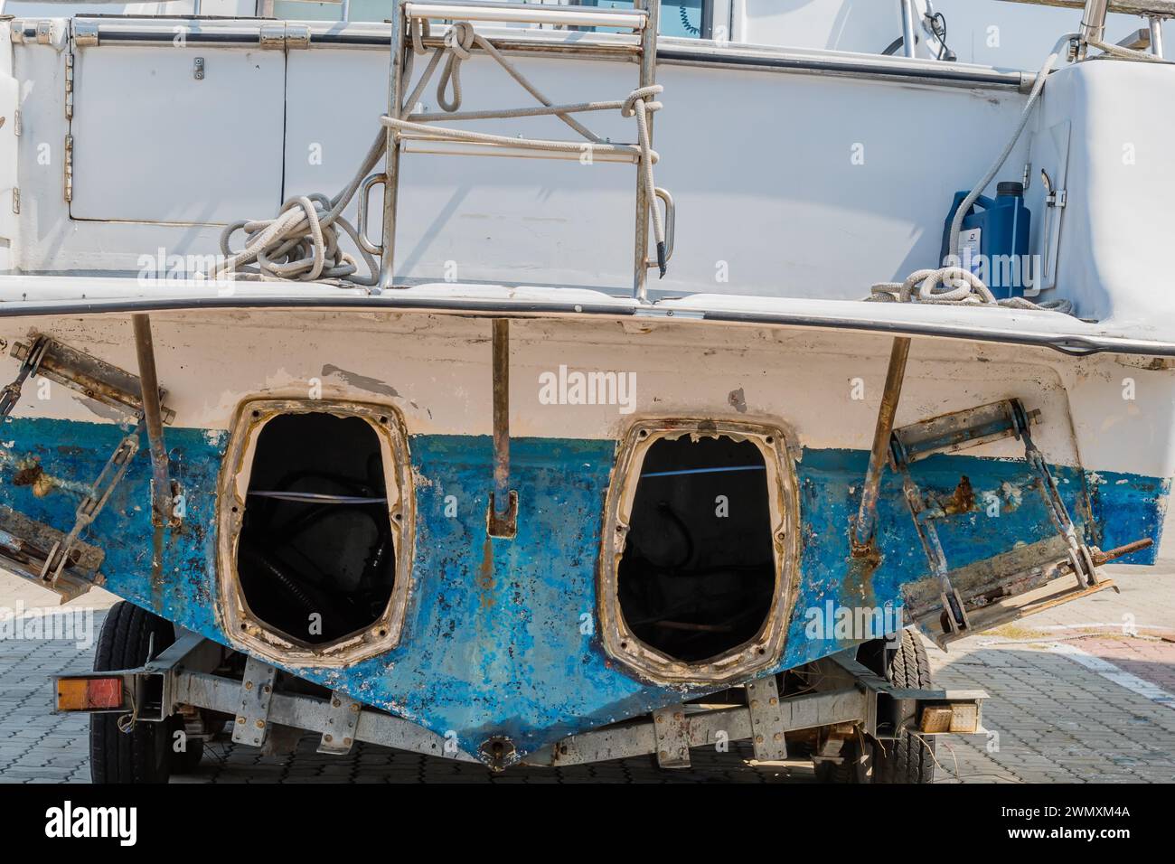 Rear view of yacht on metal trailer with two ports for missing outboard ...