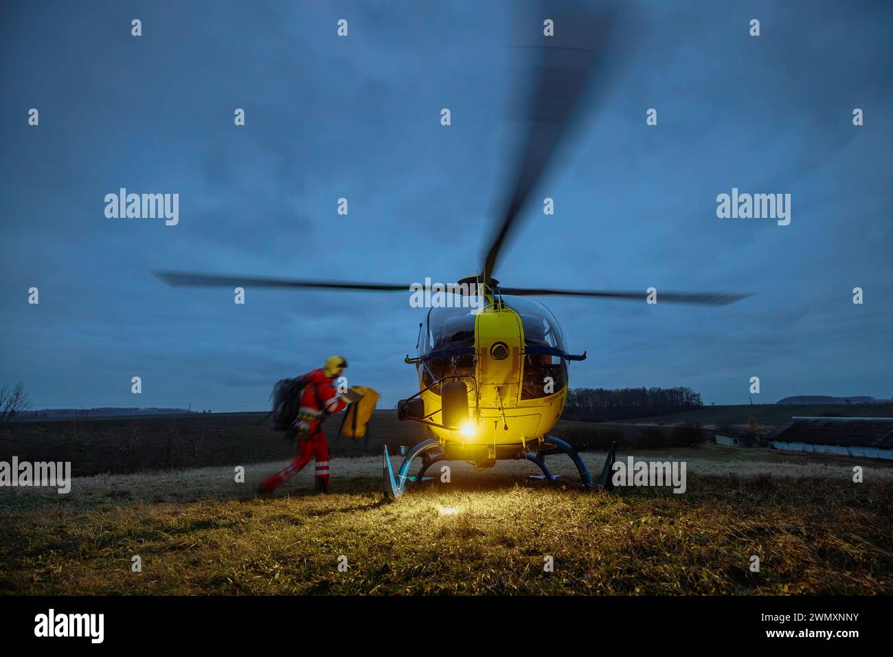 Paramedic in blurred motion running with equipment to helicopter of ...