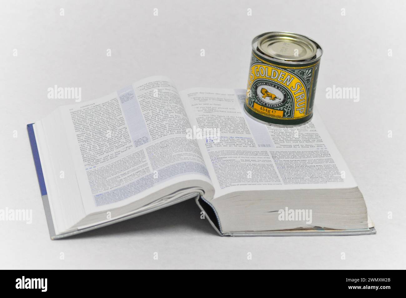 A tin of Lyle's Golden Syrup set on the open pages of a well used bible ...