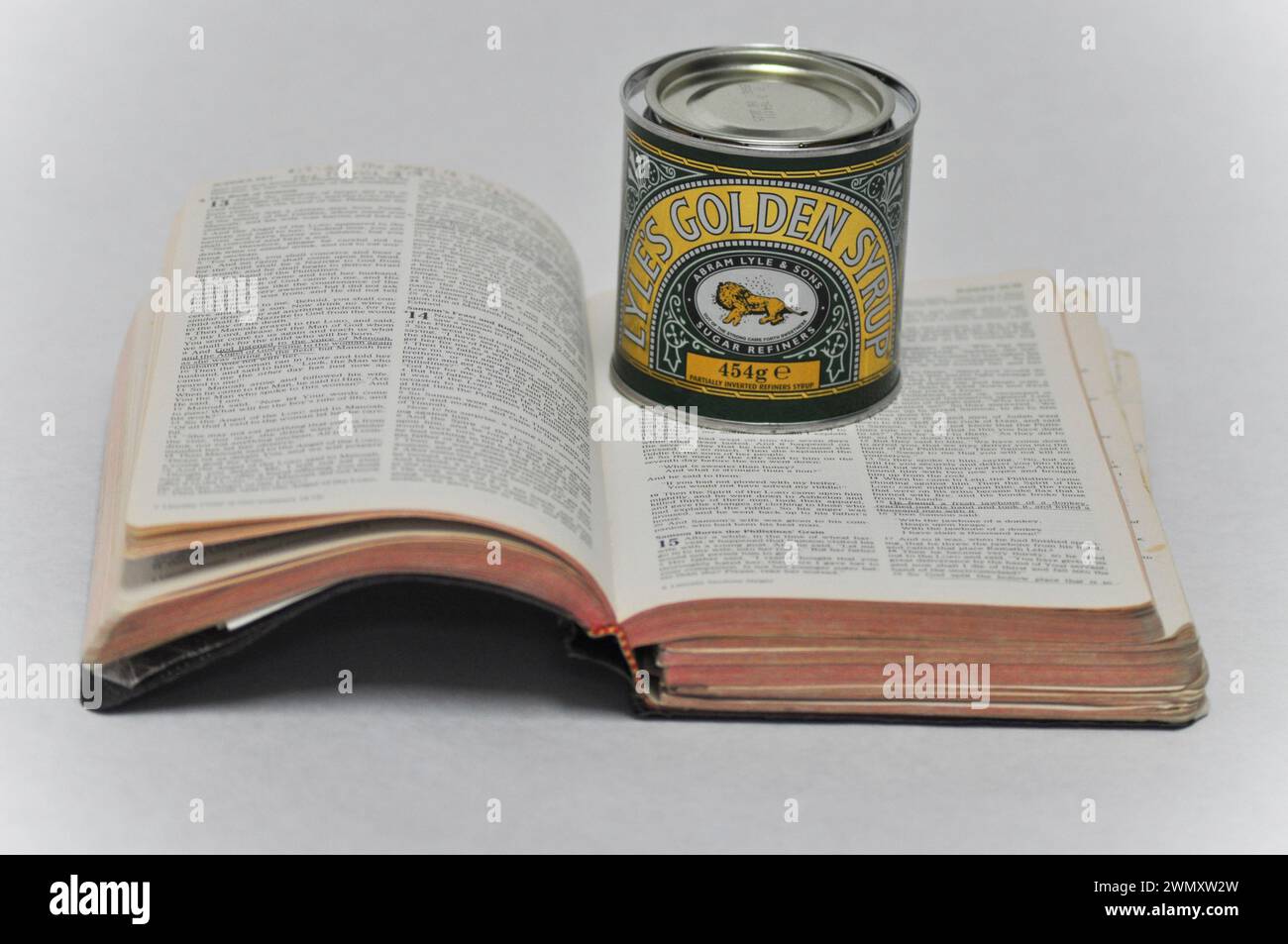 A tin of Lyle's Golden Syrup set on the open pages of a well used bible ...