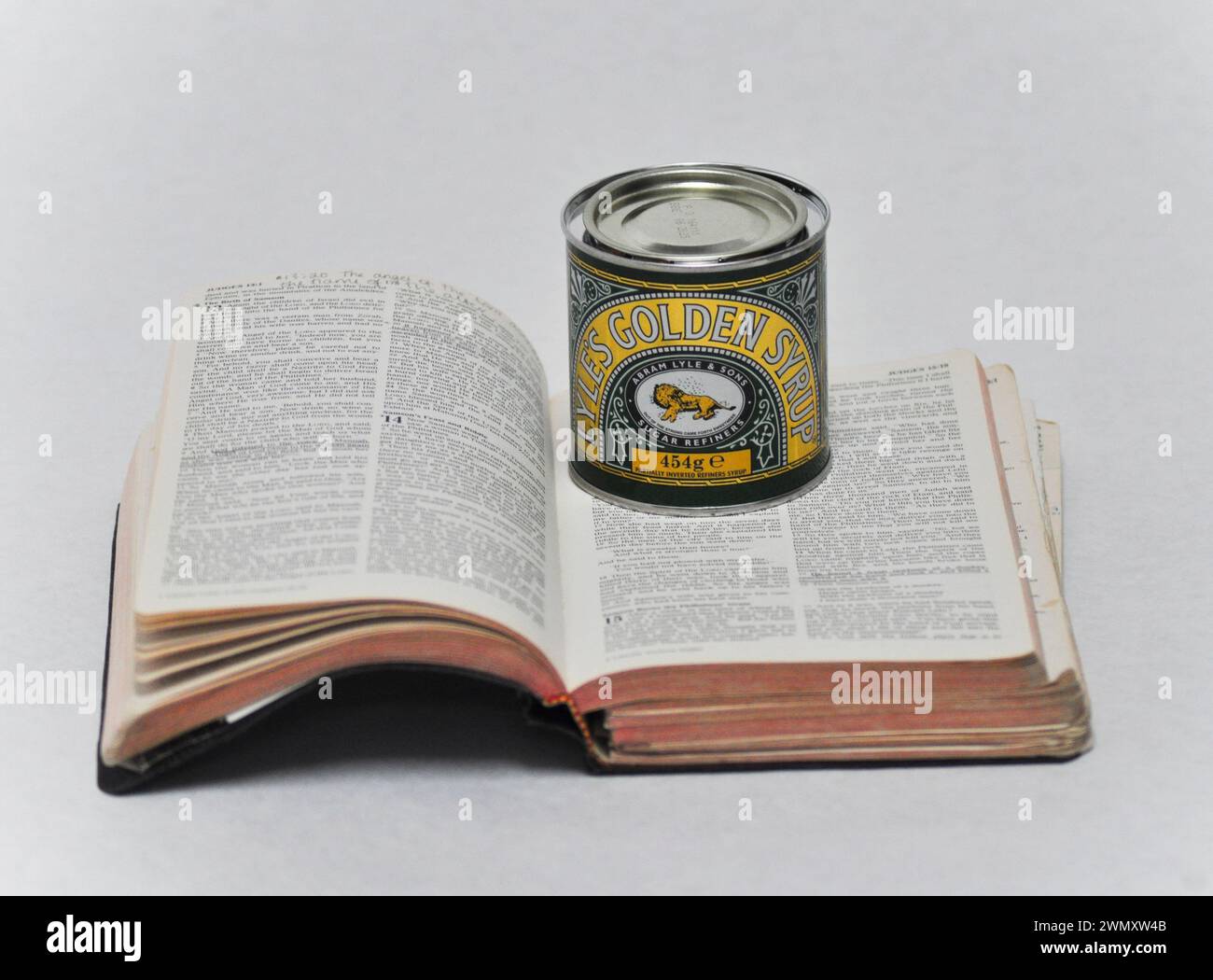 A tin of Lyle's Golden Syrup set on the open pages of a well used bible ...