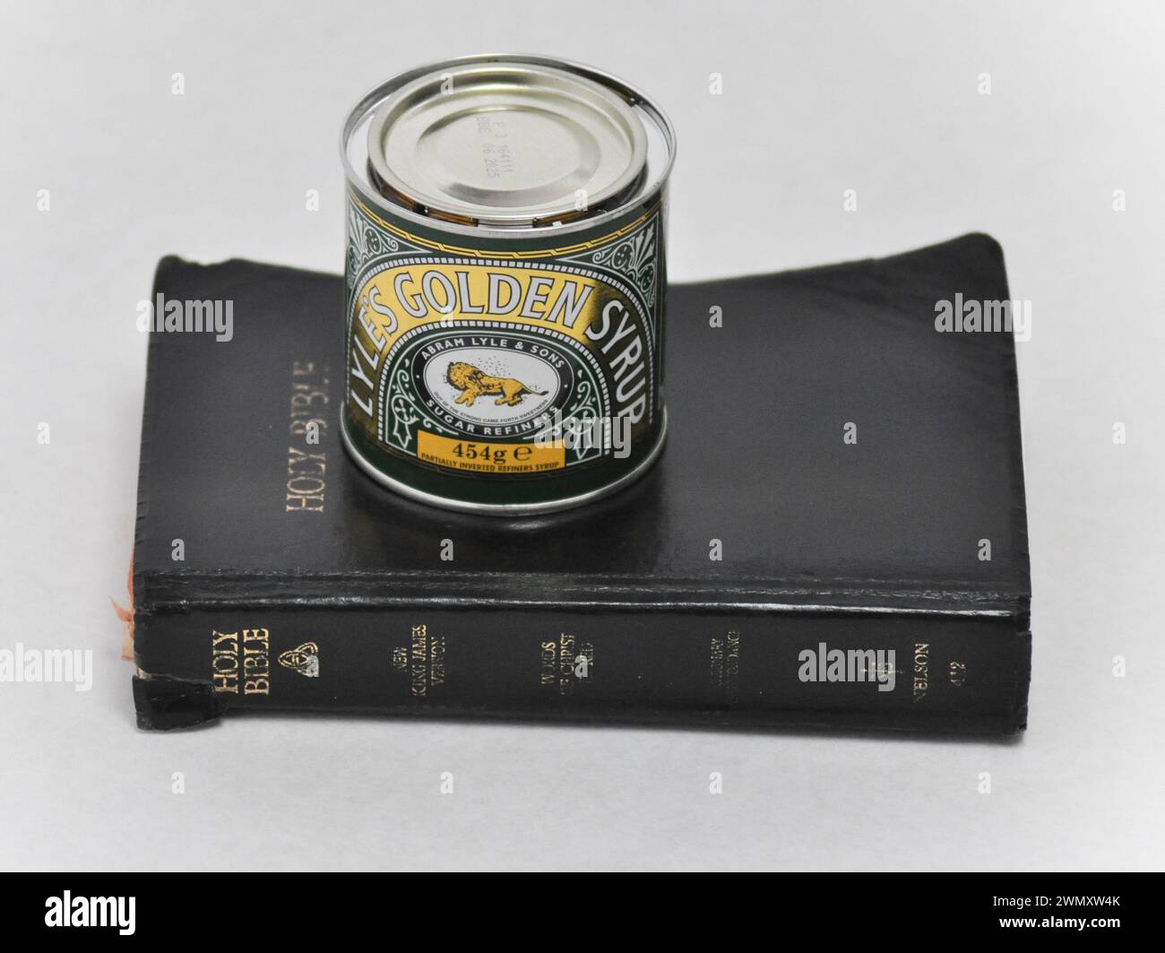 A tin of Lyle's Golden Syrup sitting on top of an old black covered ...