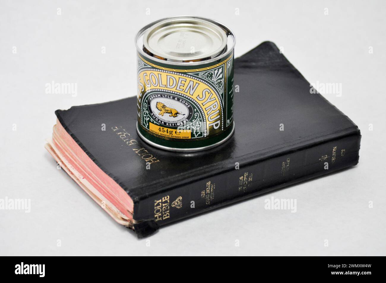 A tin of Lyle's Golden Syrup sitting on top of an old black covered ...
