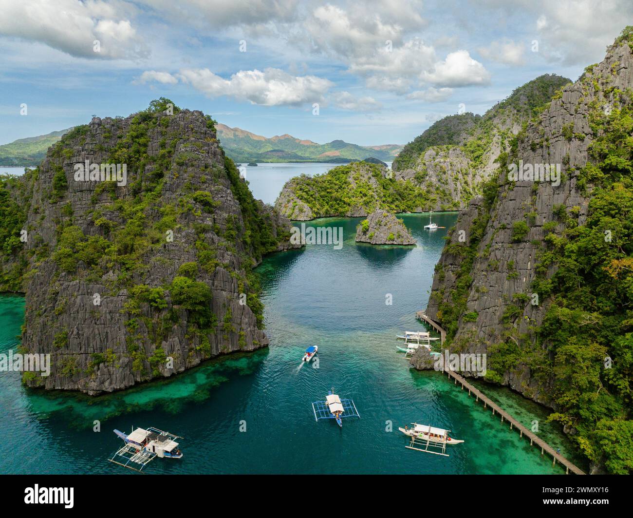 Boats over green water surrounded by splendid limestone rocks in ...