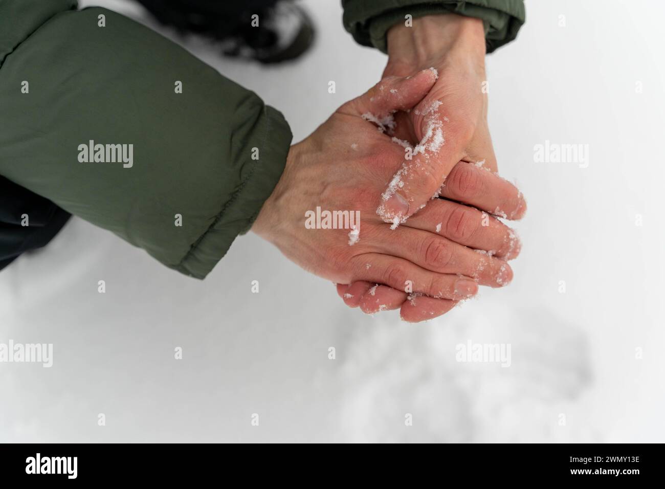 person's hands covered in snow, showing signs of resilience and ...