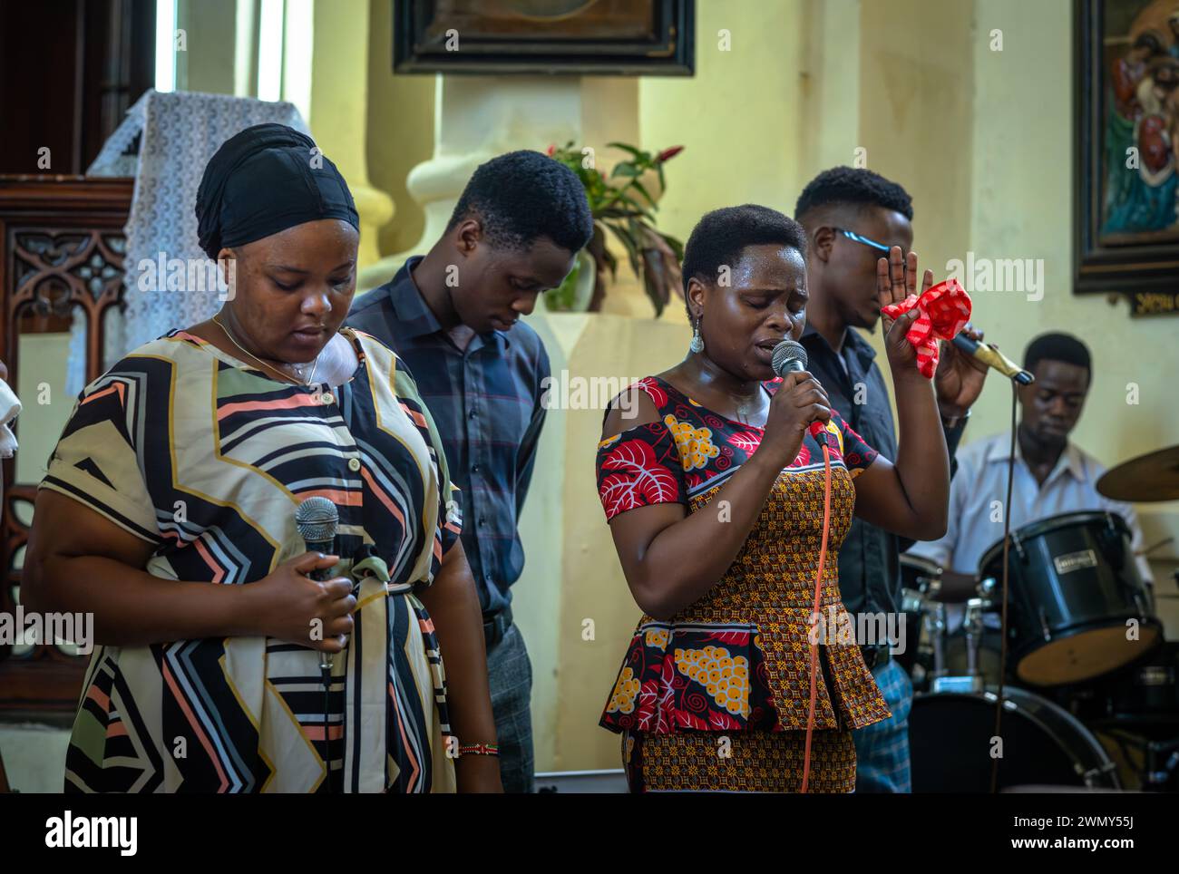 A band plays as a woman and other worshippers sing on Sunday in the ...