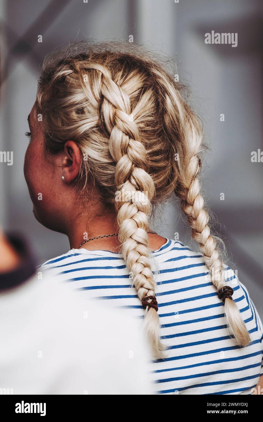 Feminine hairstyle of blonde girl from behind with 2 pretty braids ...