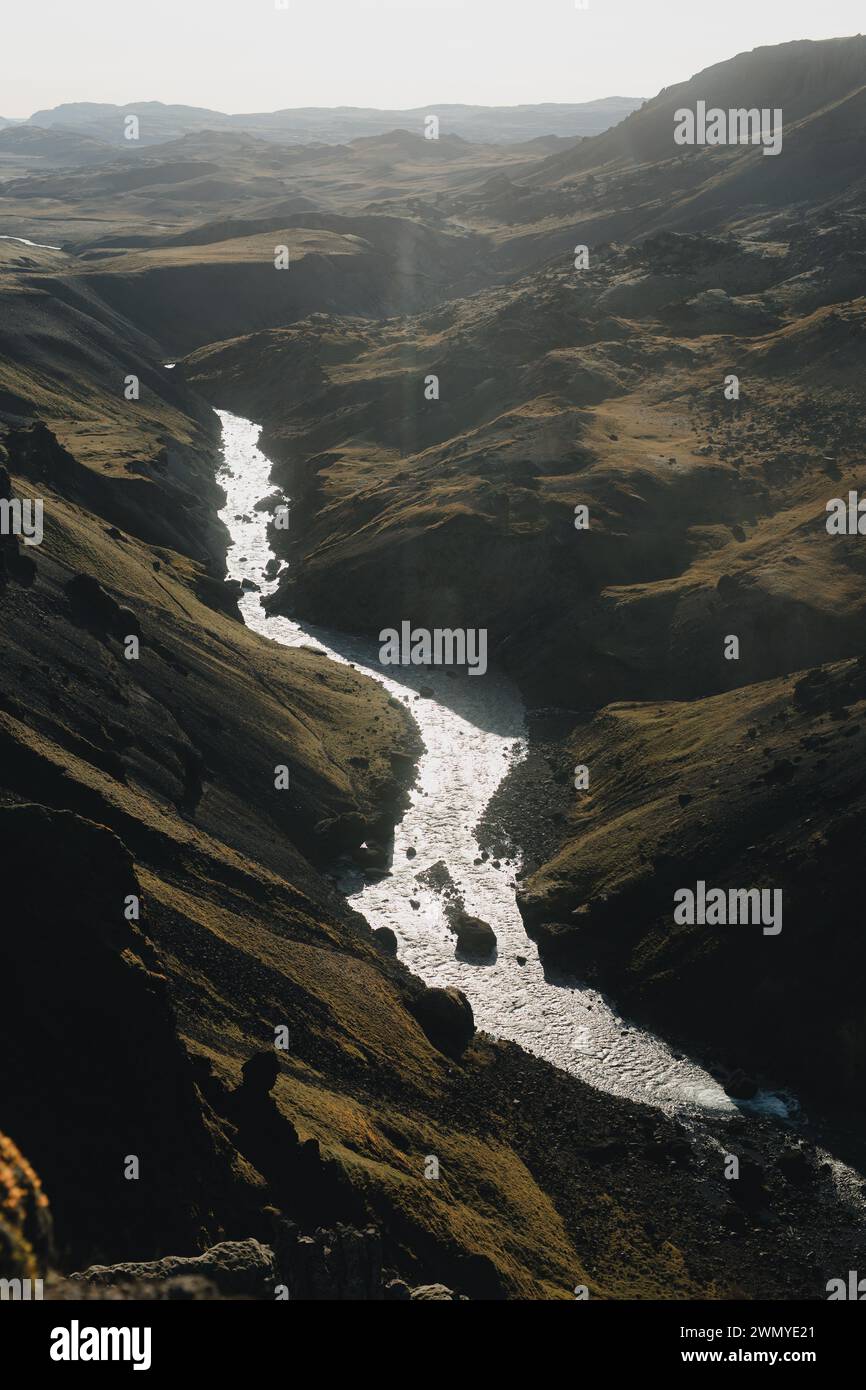 An enchanting view of a glistening river winding through the rugged ...