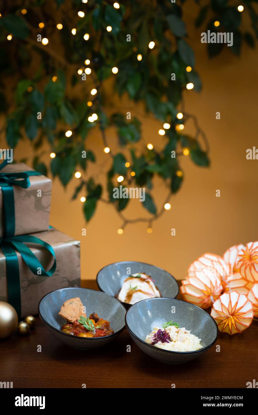 Three elegant canapes presented on small plates with a warm, festive ...
