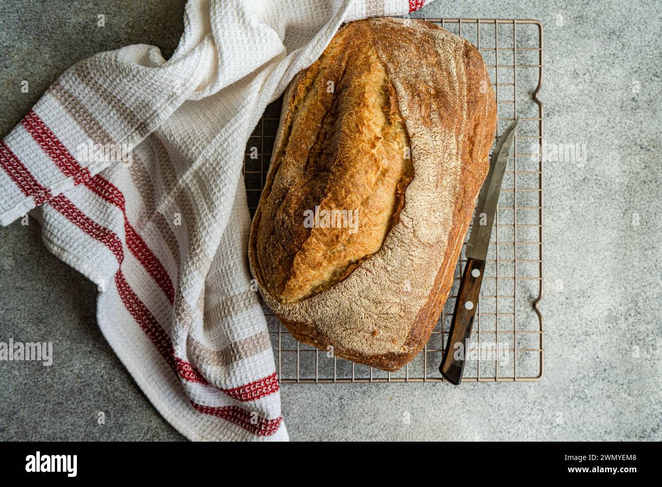 Top view of freshly baked loaf of rye sourdough bread sits cooling on a ...