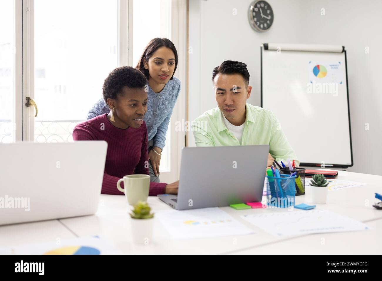 Three professionals actively engaged in a team discussion over ...