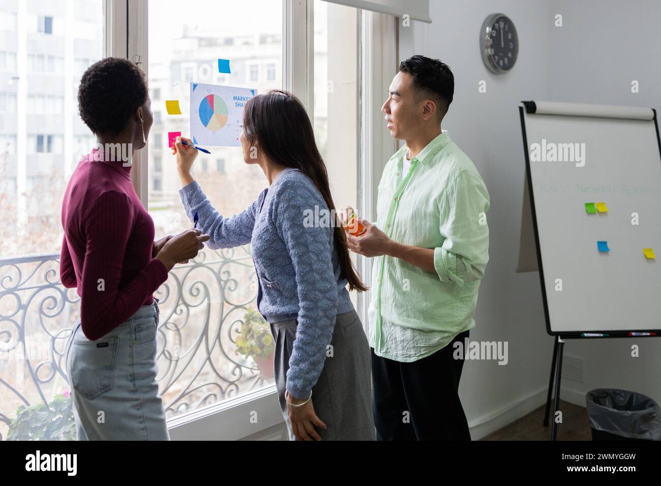 A diverse team collaborates on a project, analyzing a market share pie ...