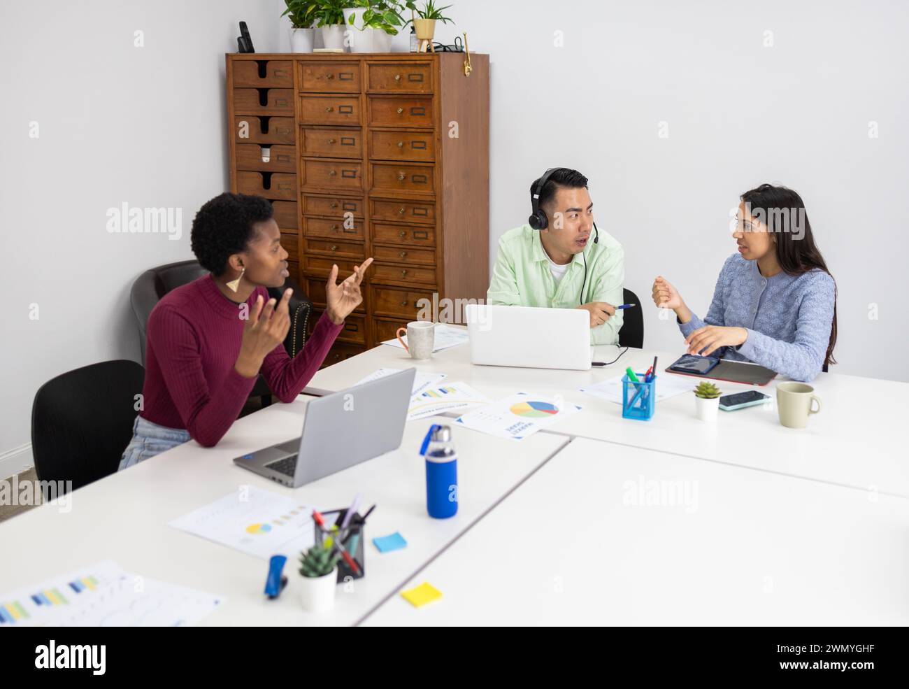 Three professionals engage in a constructive discussion at a white ...
