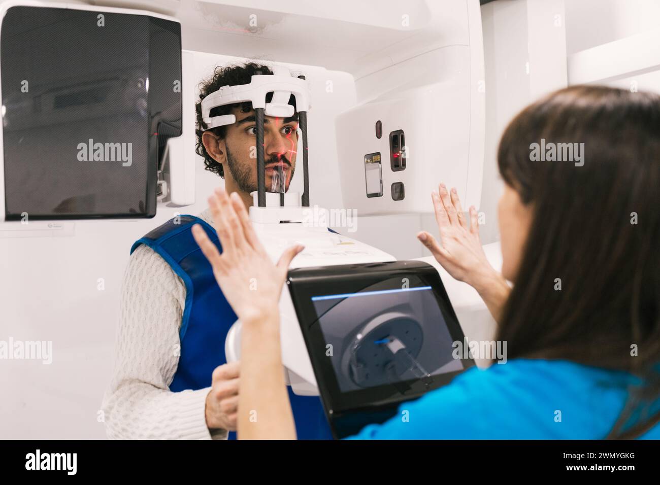 A patient undergoes a CT scan in a dental clinic with a technician ...