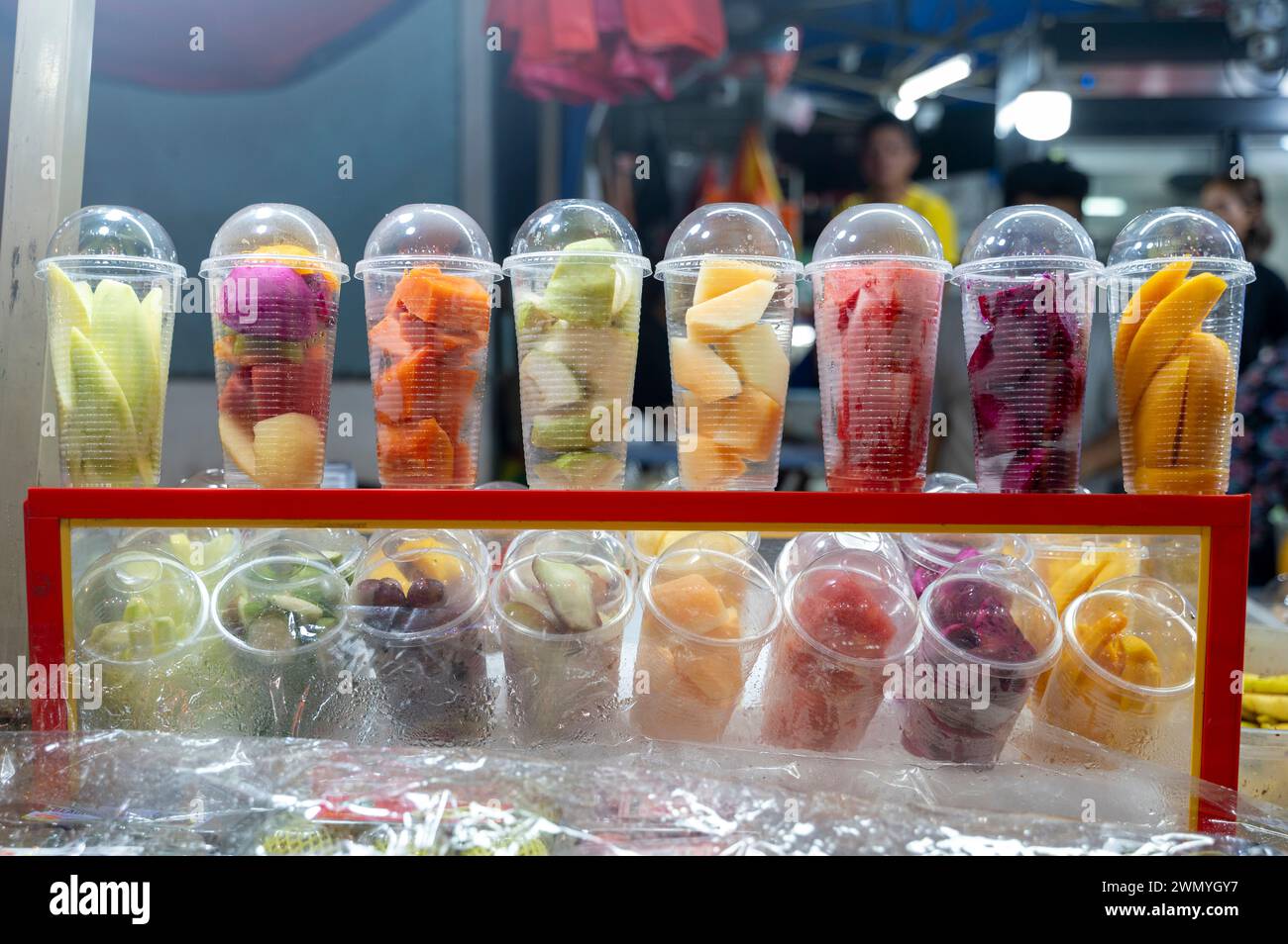 Freshly cut fruit cups on display at a Malaysian market, showcasing ...