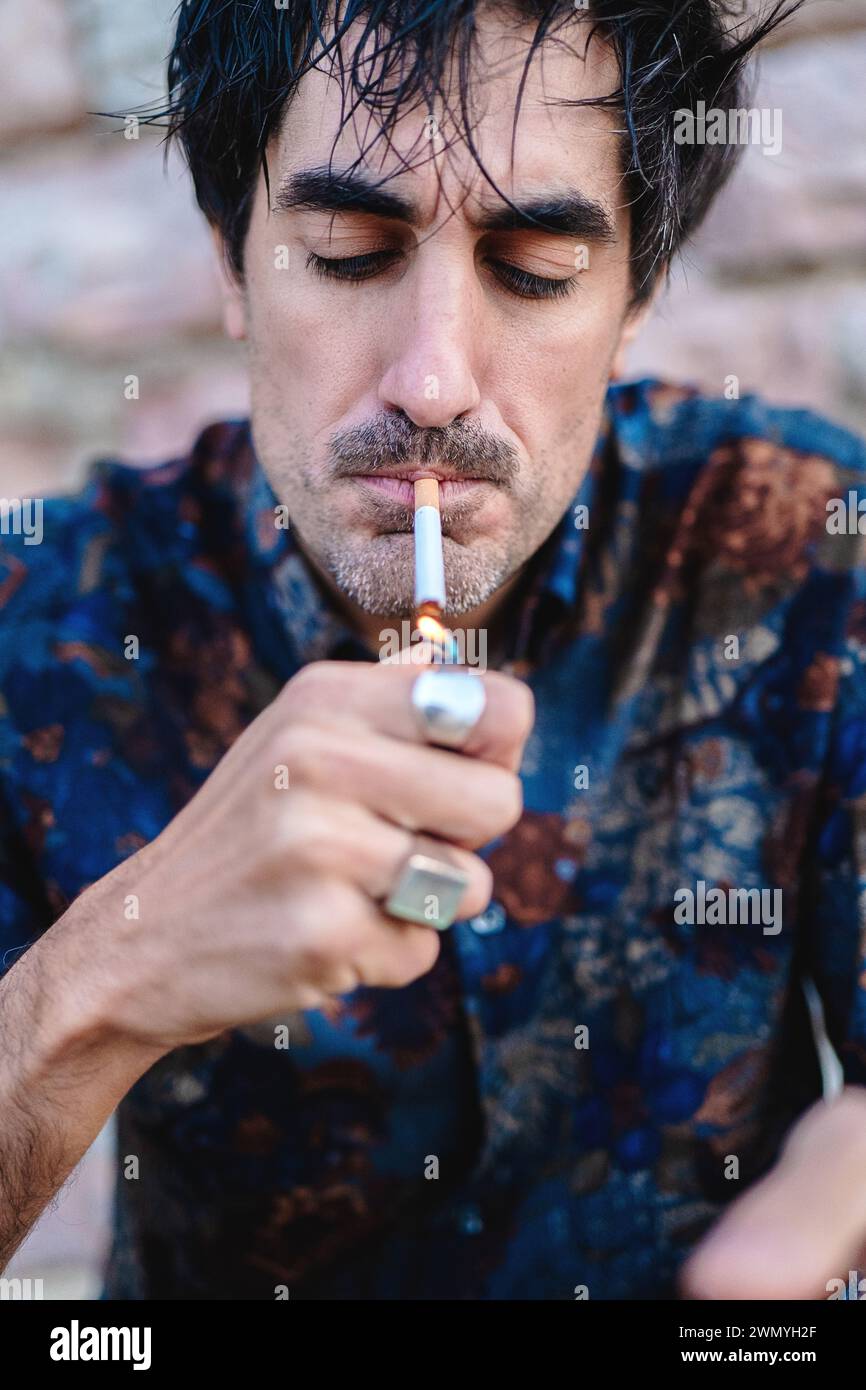 Close-up shot of a man lighting a cigarette, focusing on the lit match ...