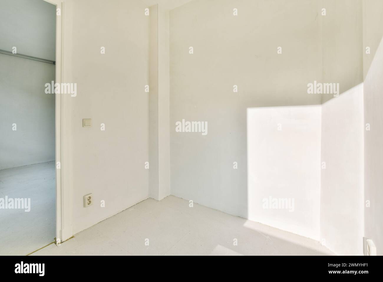 An empty room featuring a stark white interior with an open closet door ...