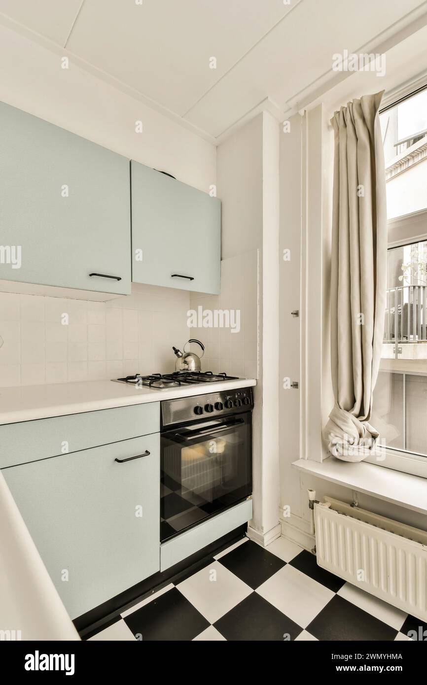 A compact light blue kitchen interior showcasing a checkered floor ...
