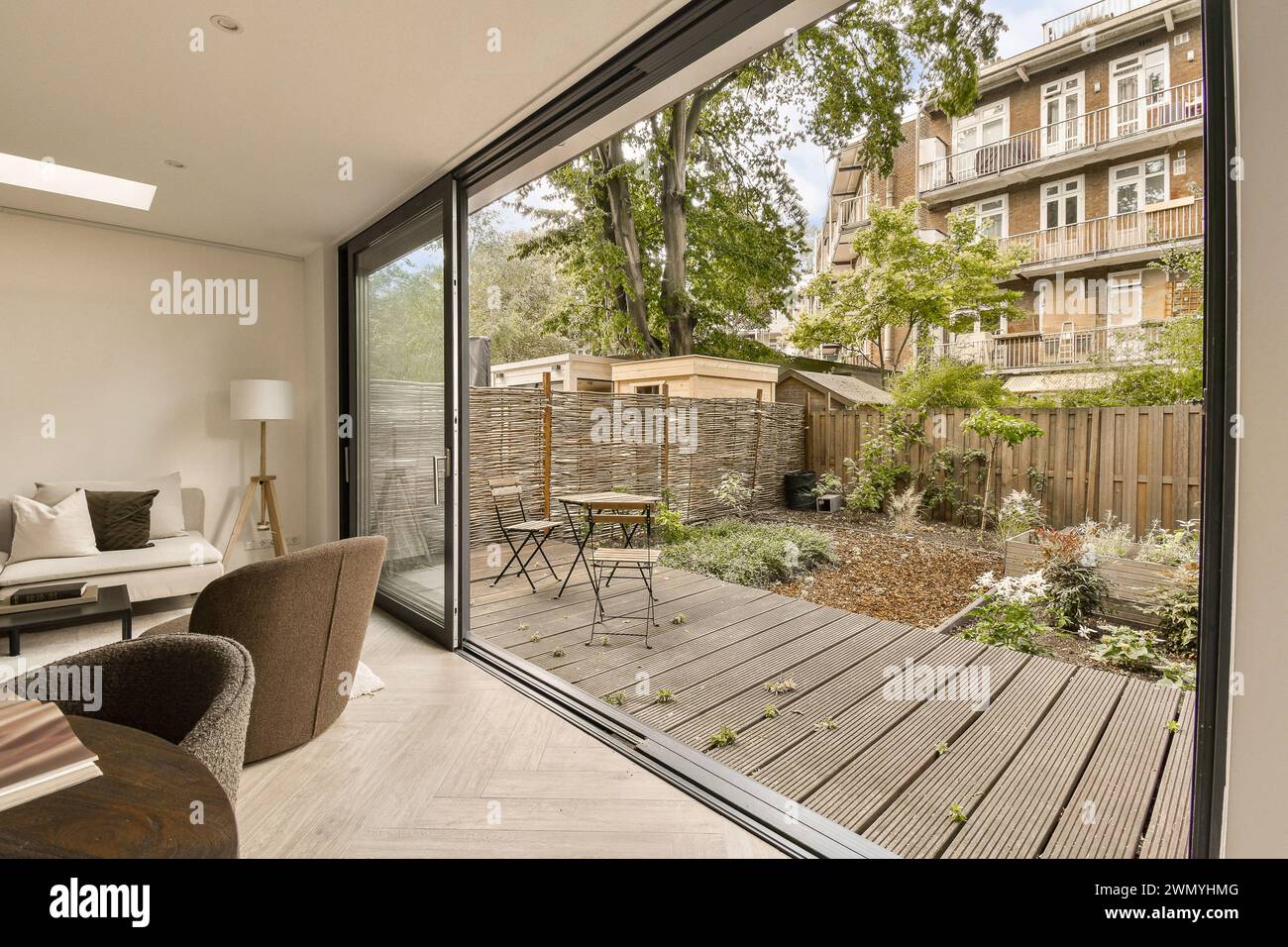 A cozy modern living room seamlessly connects to a serene garden ...
