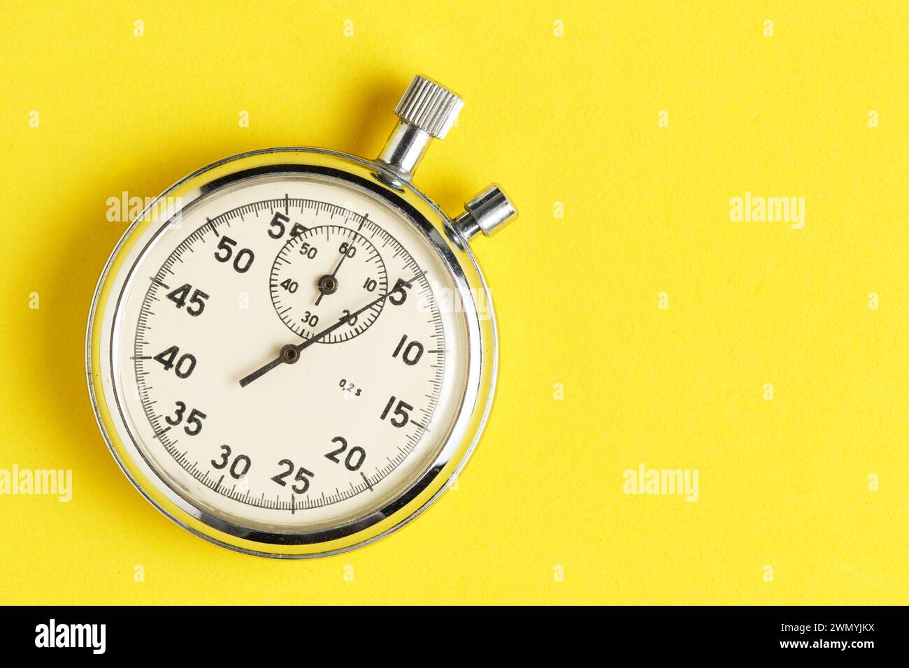 Mechanical stopwatch yellow background closeup Stock Photo - Alamy