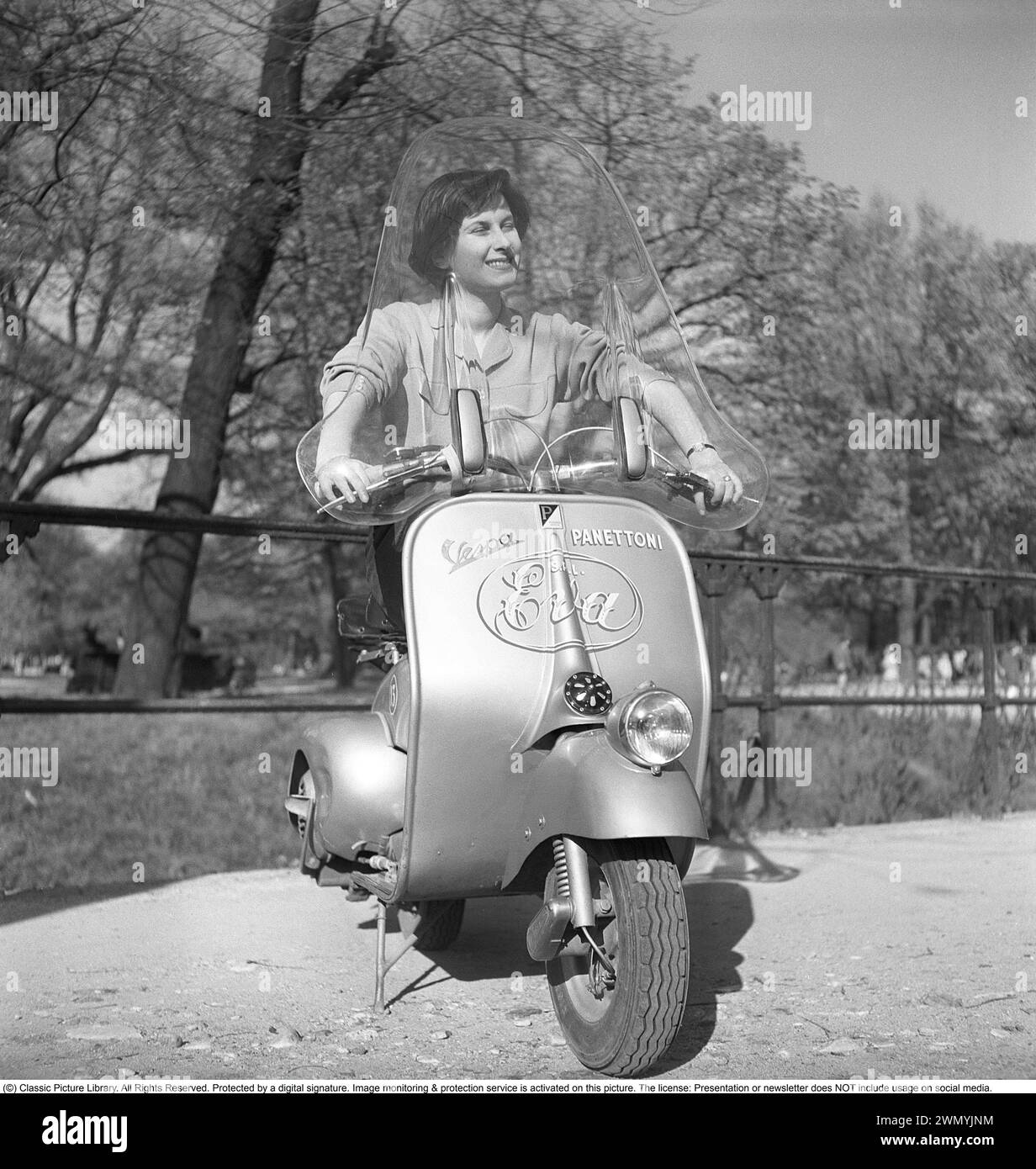 Driving in Italy in the 1950s. A young woman on a Vespa scooter in ...